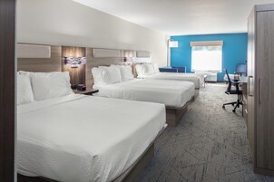 Quarto de hotel com duas camas, uma escrivaninha, uma cadeira e uma televisão.