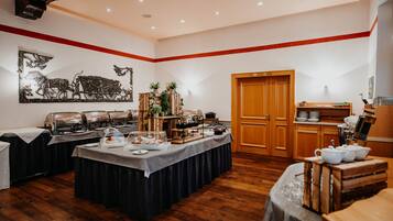 Buffet montado com diversas estações de serviço, uma porta de madeira e uma área de cozinha com utensílios e louças.