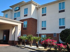 Um hotel de vários andares com fachada bege, um letreiro com a inscrição