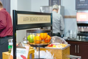 Uma estação de café da manhã com uma placa que diz 'HAPPY BREAKFAST STARTS HERE'.
