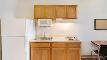 Um frigorífico/congelador grande, um micro-ondas, uma placa de cozinha