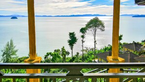 Um gazebo de madeira com vista para um lago tranquilo e montanhas ao longe.
