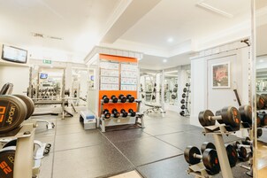 Uma academia com diversos equipamentos de exercício, incluindo halteres e aparelhos de musculação.