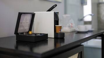 Máquina de café com uma chávena e um menu sobre o balcão.
