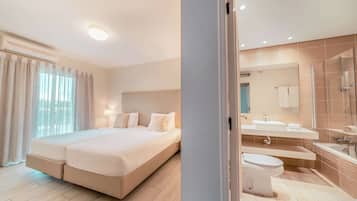 Quarto de hotel moderno com uma cama grande, banheiro com chuveiro e vaso sanitário.