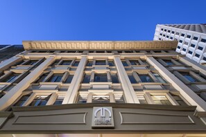 Um edifício com fachada bege, janelas amplas e a placa Miller Apartments.