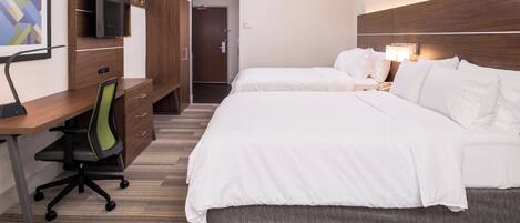 Quarto de hotel com uma mesa, duas camas, televisão e porta que dá para outro aposento.