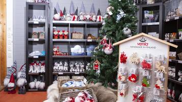 Exposição de Natal com diversas decorações, incluindo gnomos, enfeites e uma placa indicando que os produtos são feitos à mão na Finlândia.