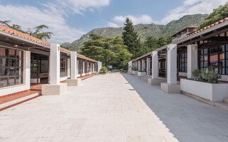 Um corredor com edifícios de ambos os lados, em direção a um cenário montanhoso.