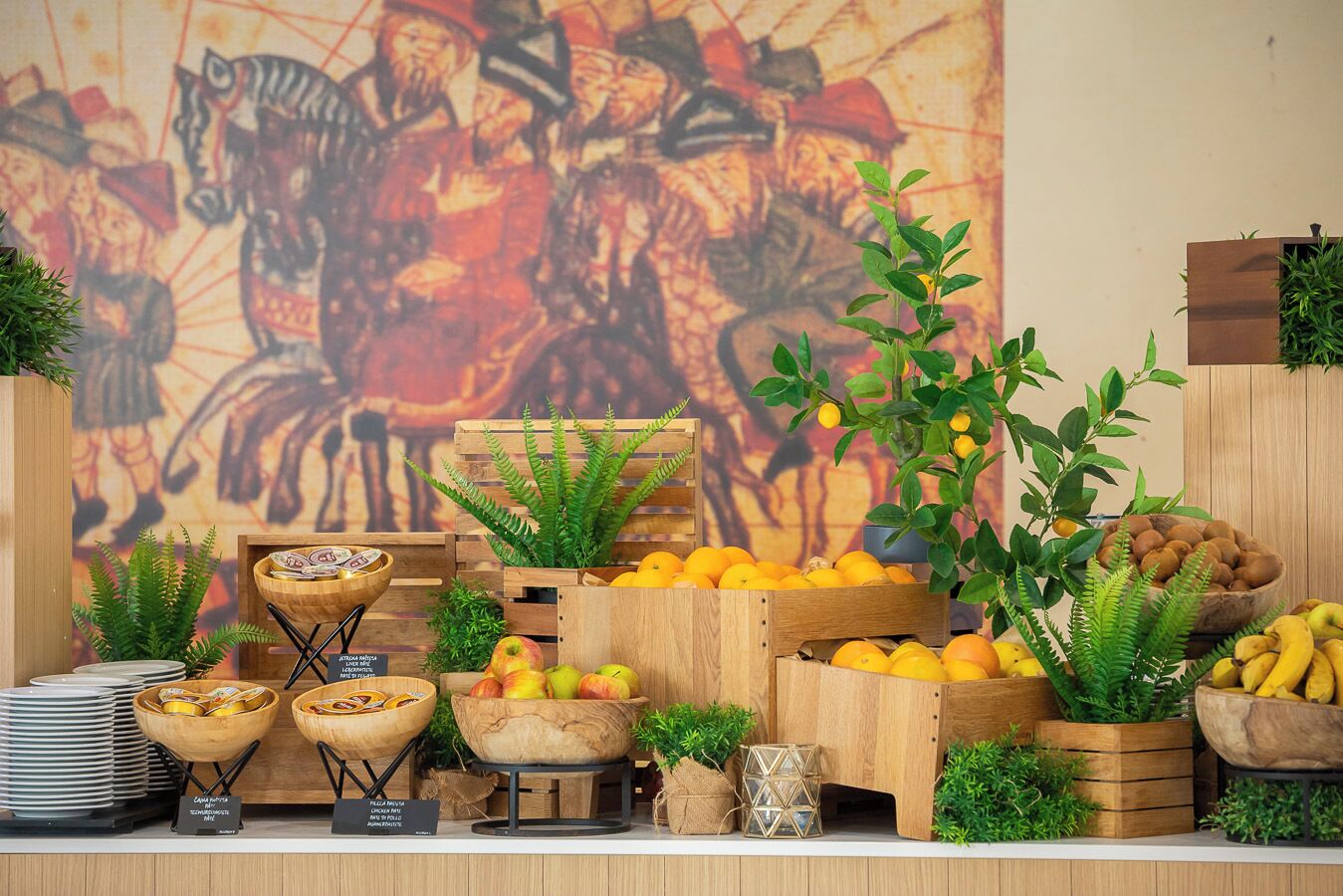 Disposição de buffet com diversas frutas e legumes, travessas de madeira e um cenário rústico.