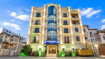 Um hotel com entrada notável, fachada de vidro ampla e uma placa indicando ser um Premier Hotel.