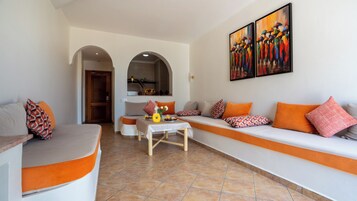 Uma sala de estar com um sofá, uma mesa de centro e um quadro na parede.