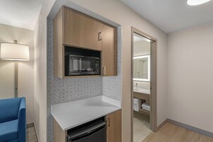 Cozinha compacta com micro-ondas, pia e armário.