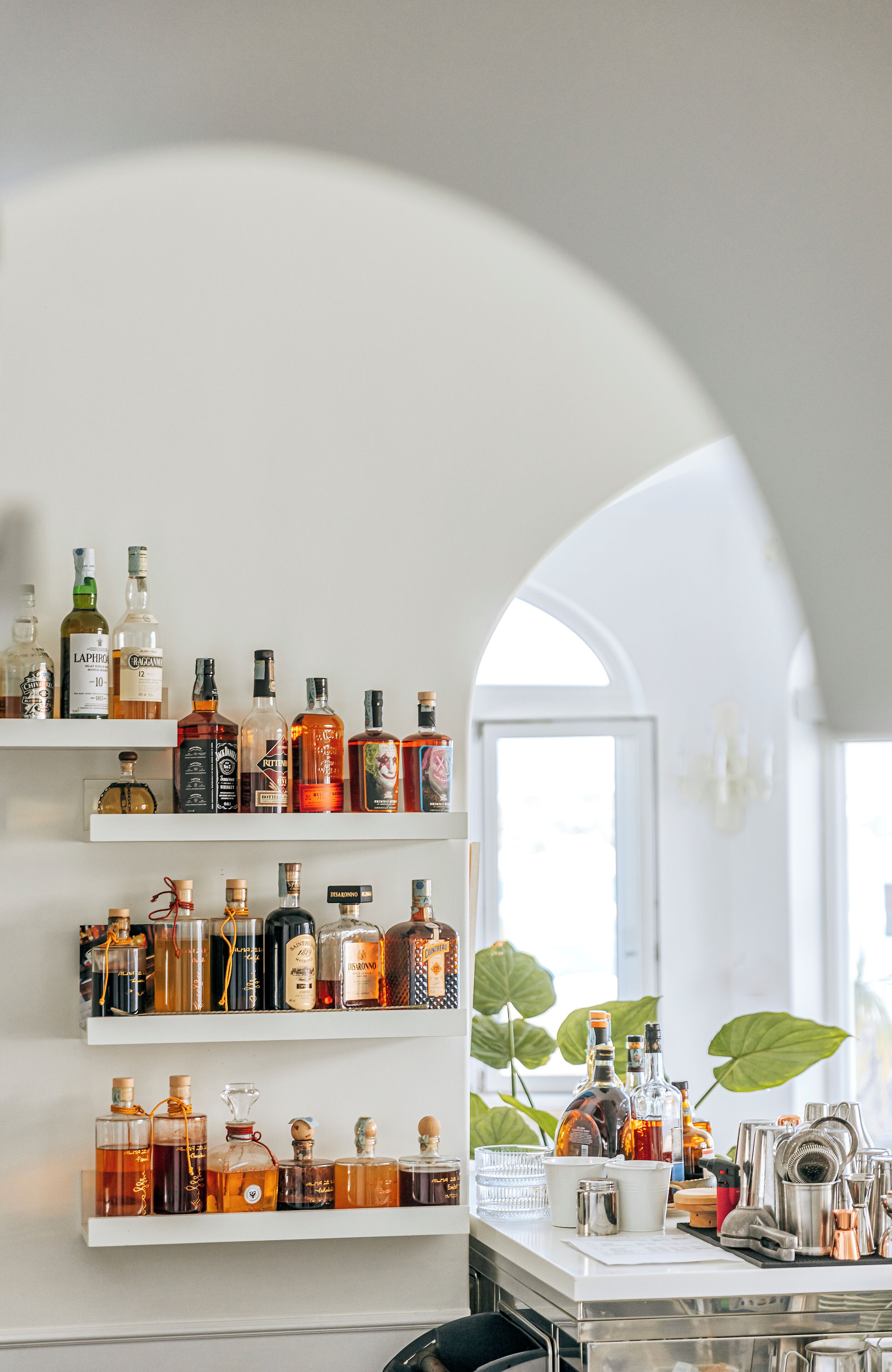 Uma área de bar com prateleiras cheias de garrafas de bebidas e utensílios de bar.