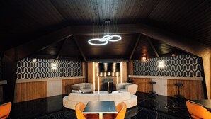 Um interior moderno com área de estar circular, uma mesa central e um lustre de design único.