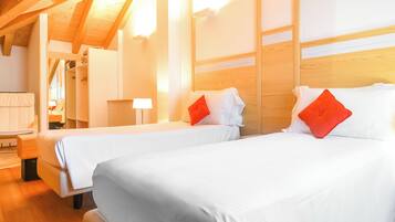 Quarto com duas camas, vigas de madeira e piso de madeira.