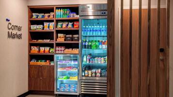 Uma mercearia de esquina com prateleiras cheias de lanches, bebidas e outros produtos alimentícios.