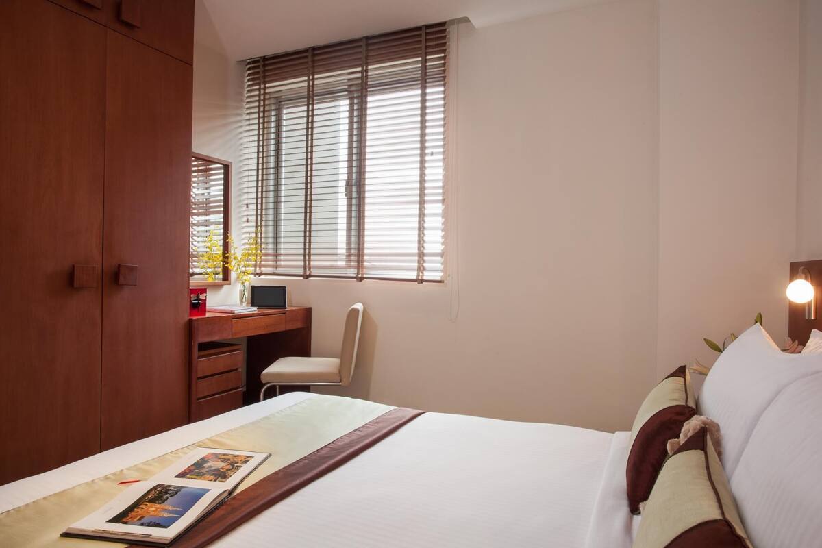 Quarto com cama, escrivaninha, cadeira e guarda-roupa.
