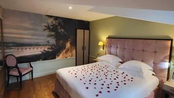 Quarto com uma cama grande, uma cadeira, uma escrivaninha e um mural na parede.