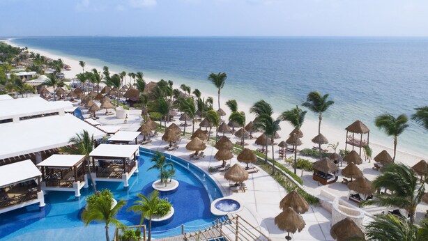 Um resort com piscina, praia e vista para o oceano.