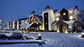 Um hotel grande e com vários andares, com uma paisagem coberta de neve.