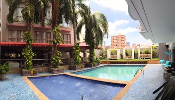 Piscina interna com piso ladrilhado e áreas de descanso com assentos.