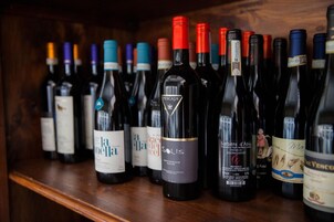Diversas garrafas de vinho em uma prateleira de madeira.