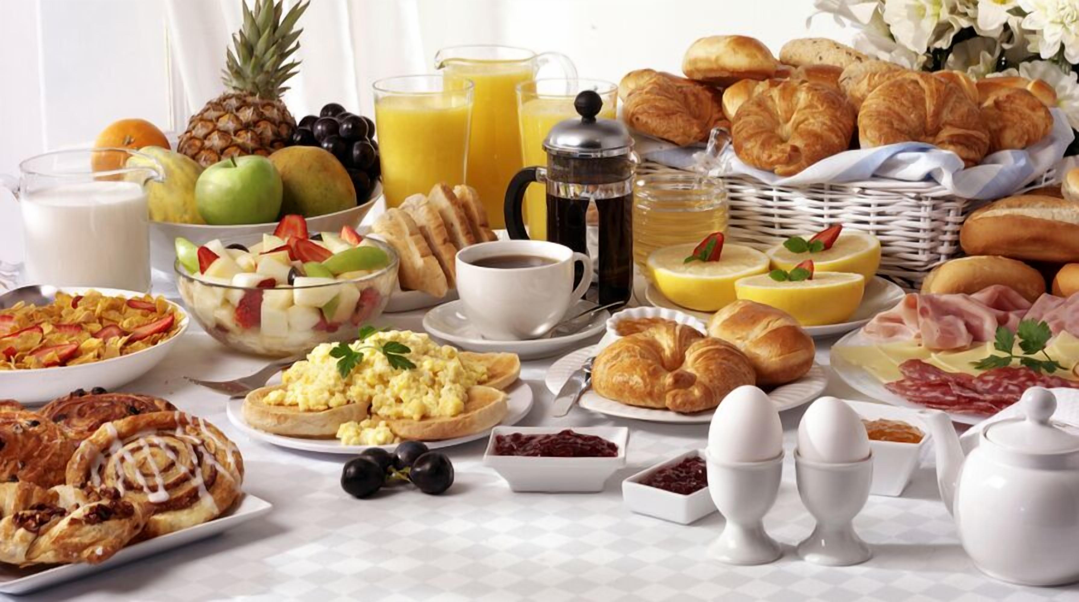 Um buffet de café da manhã com diversos alimentos e bebidas.