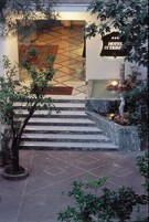 Entrada de hotel com escadas que levam a uma área de recepção.