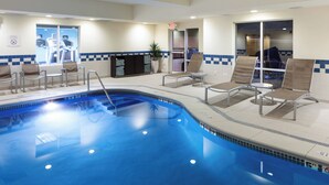 Piscina com espreguiçadeiras, sala de trocas e área de recepção.