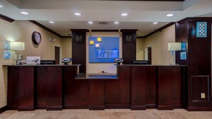 Uma receção com um relógio, o sinal Holiday Inn Express e um balcão de check-in.