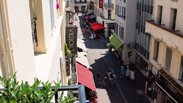 Vista da rua com um hotel chamado "HOTEL LA FAYETTE" e uma placa para "FA Special Asia".