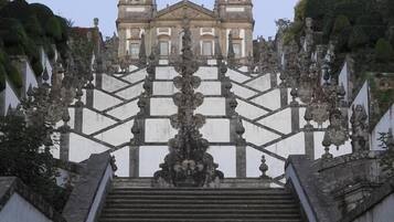 Uma escadaria imponente que leva a um edifício histórico com duas torres sineiras.