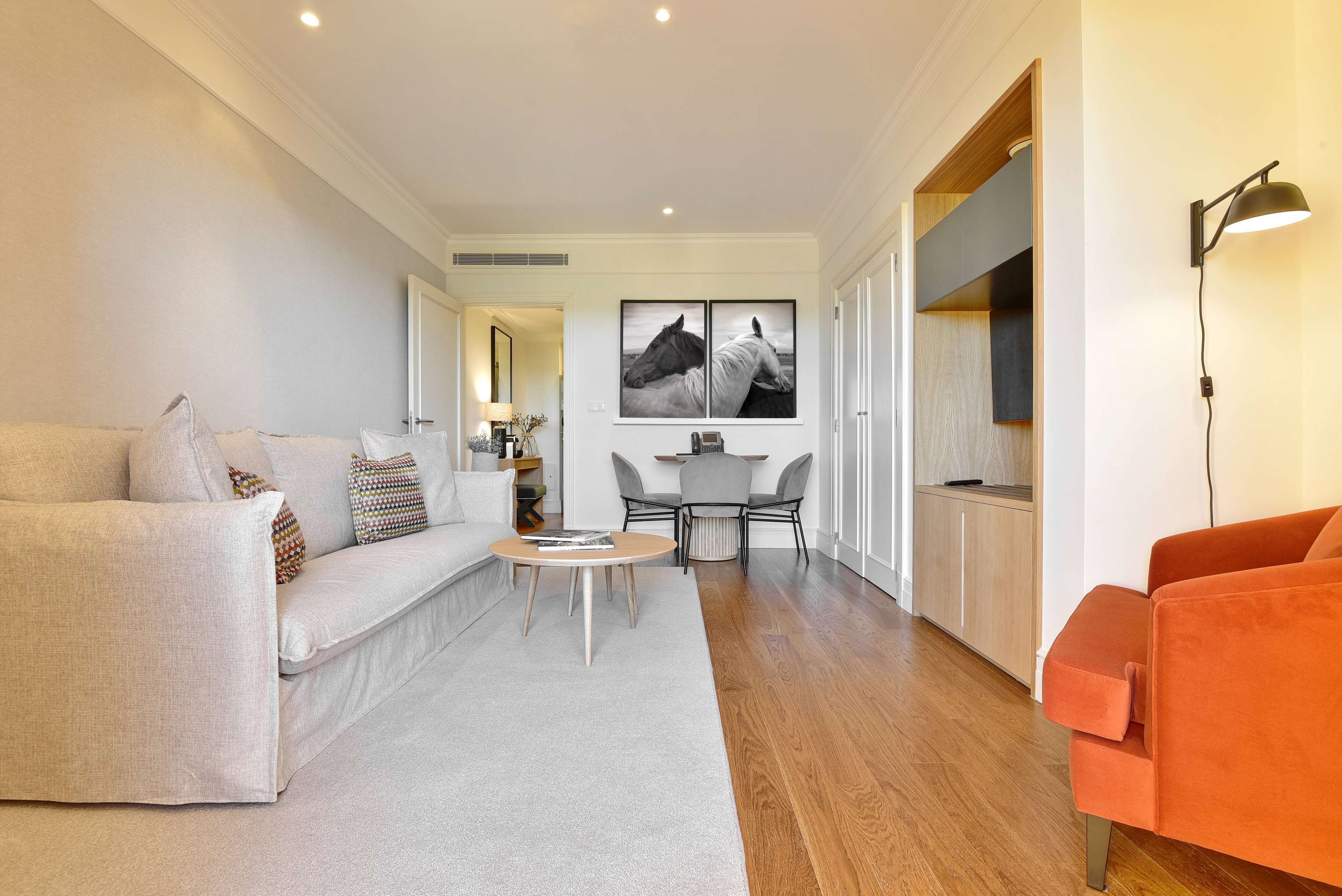 Uma sala de estar moderna com sofá, mesa de centro e área de jantar com cadeiras.