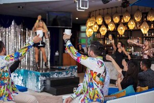 Espaço de bar com assentos e palco para apresentações.
