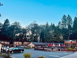 Pousada Shasta com Restaurante Harvest, rodeada por árvores e carros estacionados.