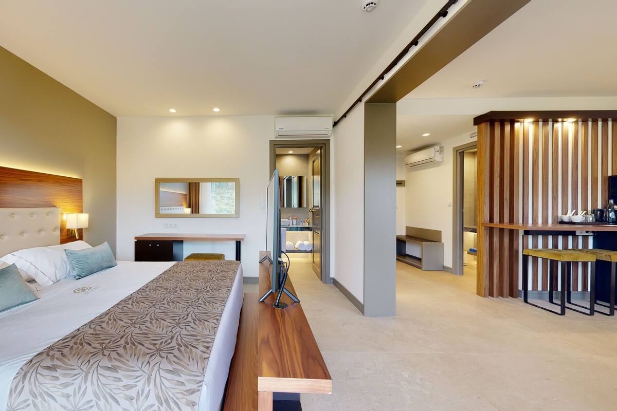 Quarto de hotel moderno com uma cama grande, uma escrivaninha e um closet espaçoso.