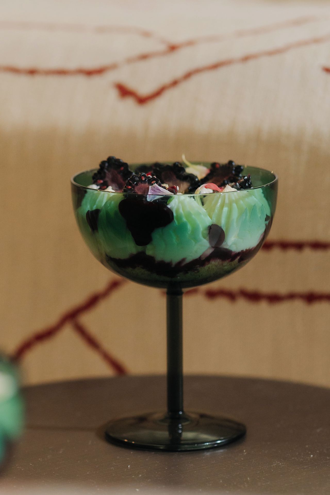 Uma sobremesa em uma tigela de vidro sobre uma mesa.