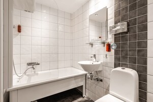 Um banheiro moderno com banheira, pia e vaso sanitário.