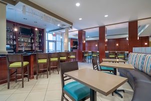Um restaurante com mobiliário de madeira, área de bar e espaço para sentar.