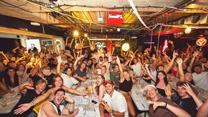 Um espaço interior movimentado, com mesas e cadeiras dispostas para socializar.