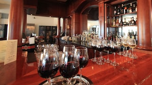 Uma área de bar com vários copos de vinho e garrafas.