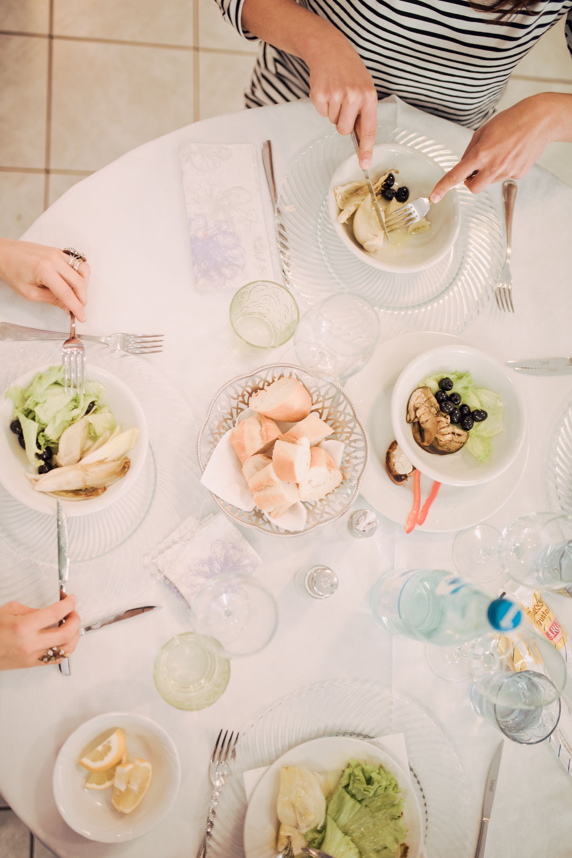 Uma mesa de jantar redonda com diversos pratos e utensílios.
