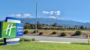 Placa do Holiday Inn Express & Suites com montanhas ao fundo.