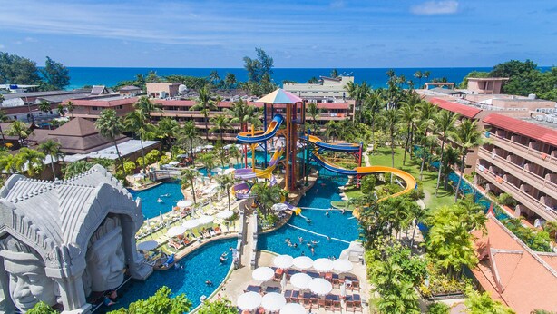 Um resort com uma piscina grande, toboáguas e vista para o oceano.