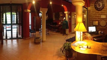 Um hall de entrada com uma mesa de recepção de madeira, uma luminária e um relógio na parede.
