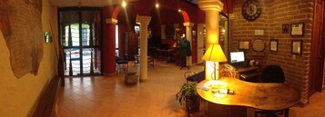 Um hall de entrada com uma mesa de recepção de madeira, uma luminária e um relógio na parede.