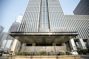 Um edifício moderno com entrada destacada e uma placa com a inscrição 'WandaVista'.