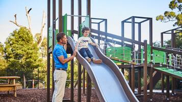 Um parquinho infantil com um escorrega e estruturas de escalada.