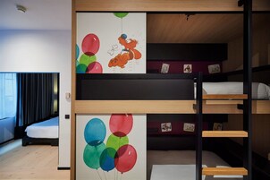 Quarto com beliche, uma obra de arte pendurada na parede com balões e um personagem de desenho animado.